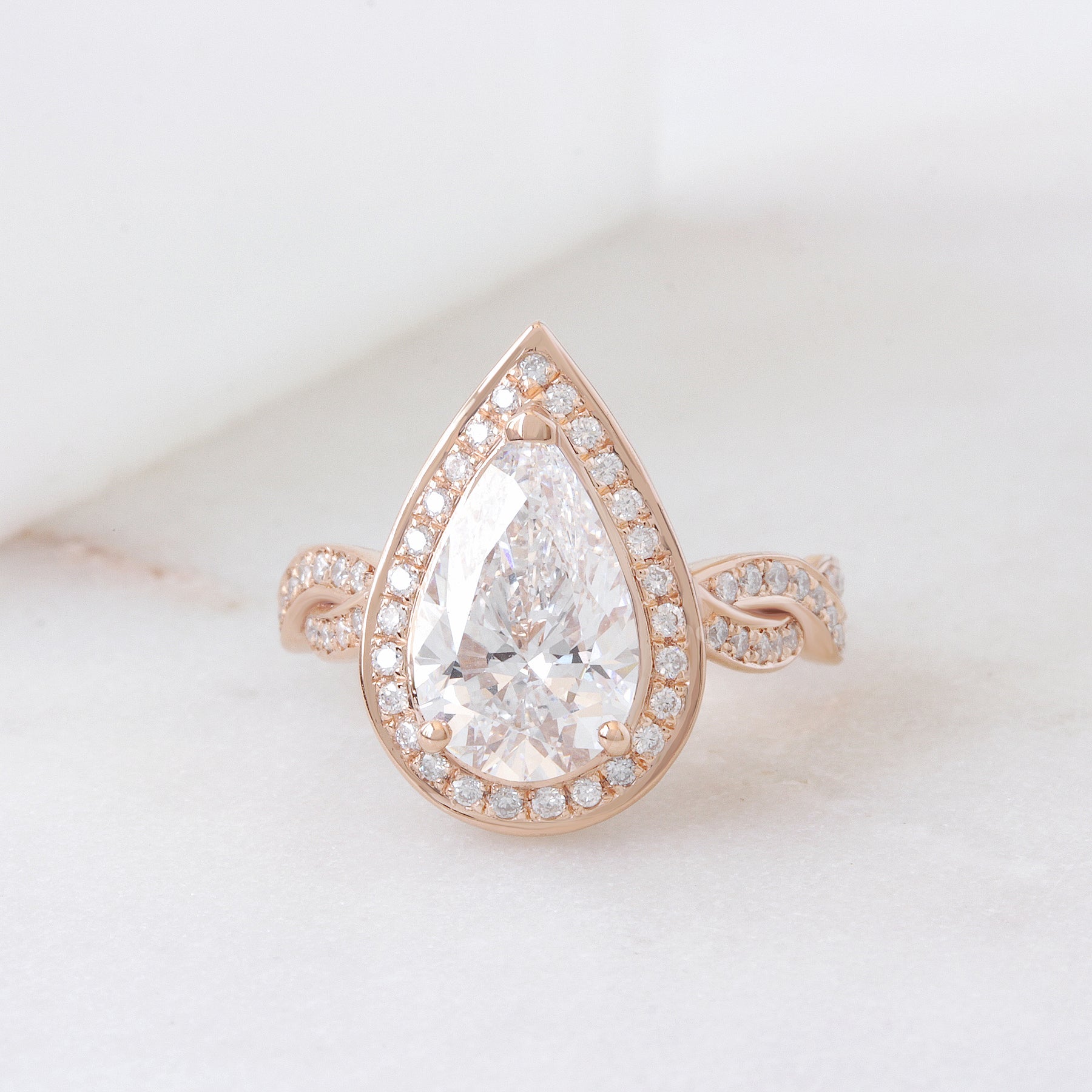 Pear diamond with diamond halo and infinity twist shank engagement ring ...